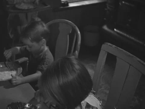 1930s: Poor kids eat around kitchen tabl... | Stock Video | Pond5
