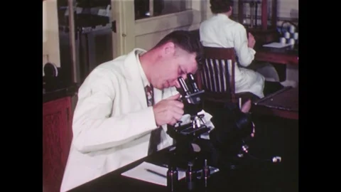 1940s: Scientist seated at a desk peerin... | Stock Video | Pond5