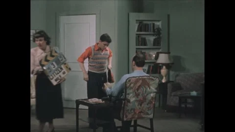 1940s: Slate. Boy in a sweater vest talk... | Stock Video | Pond5