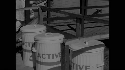 1940s: Three garbage cans. Two scientist... | Stock Video | Pond5