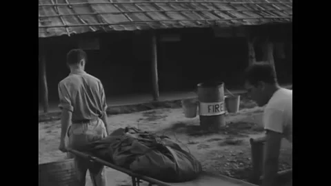 1945 - Two men carry a stretcher with hu... | Stock Video | Pond5