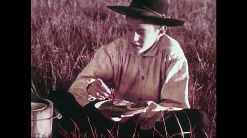 1950s: Boy eating on grass. Family loads... | Stock Video | Pond5