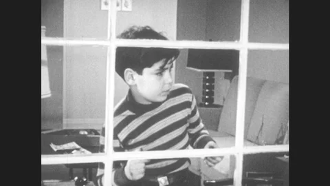 1950s: Boy inside house looks out window... | Stock Video | Pond5