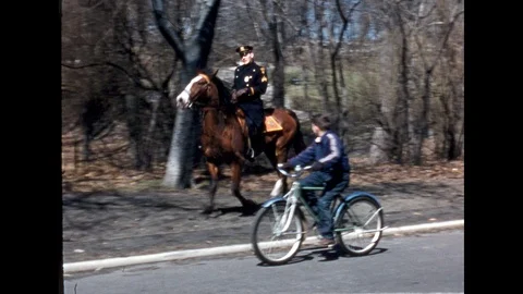 1950s: Boy rides bike past mounted polic... | Stock Video | Pond5