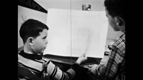 1950s: Boys look at paper. Boy writes sc... | Stock Video | Pond5