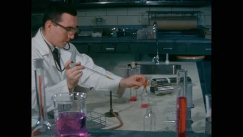 1950s: Man in lab coat sits at counter, ... | Stock Video | Pond5