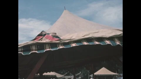 1950s: Man raises a canvas pavilion. He ... | Stock Video | Pond5