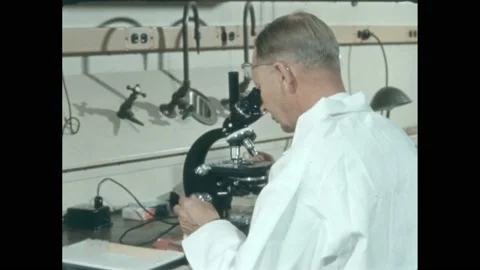 1950s: Man wears lab coat, sits at bench... | Stock Video | Pond5