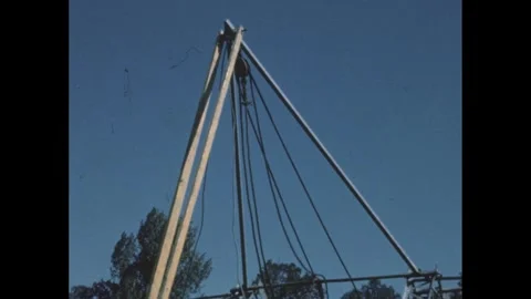 1950s: Poles push up a pulley. Men attac... | Stock Video | Pond5