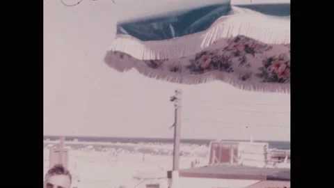 1950s: Sandy beach with bathers and umbr... | Stock Video | Pond5