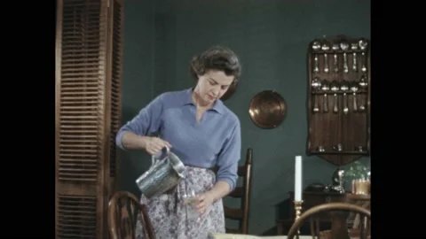 1950s: Woman pours water from a pewter p... | Stock Video | Pond5