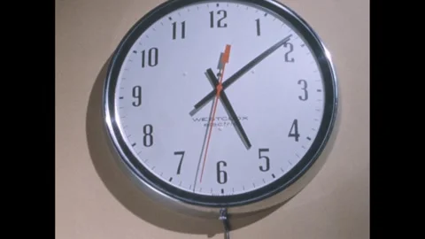 1960s: Clock on wall, hands turn over cl... | Stock Video | Pond5