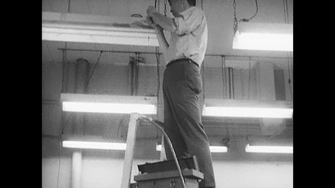 1960s: Man stands on ladder in officer w... | Stock Video | Pond5