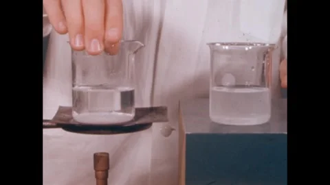 1960s: Two beakers of water: one on Buns... | Stock Video | Pond5