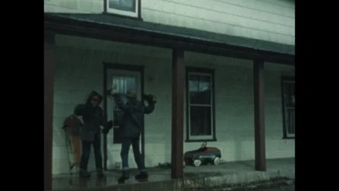 1960s: Two boys run under house front aw... | Stock Video | Pond5