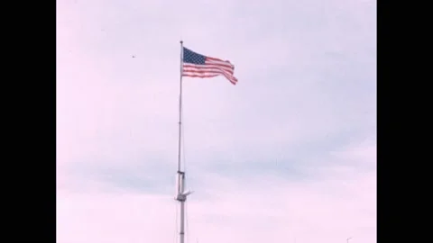 1960s: US flag flies on pole over buildi... | Stock Video | Pond5