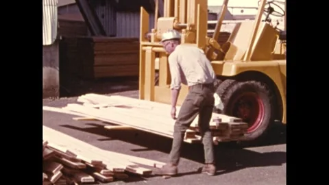 1970s: Forklift drops load of lumber. Ma... | Stock Video | Pond5