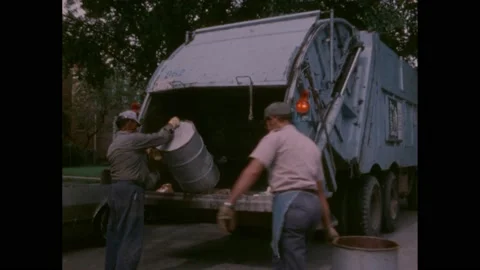 1970s: Garbage collectors dump bins into... | Stock Video | Pond5