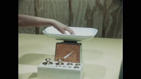 1970s: Hand points to scale, scale chang... | Stock Video | Pond5
