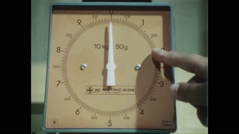 1970s: Hand points to scale, scale chang... | Stock Video | Pond5