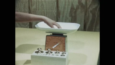 1970s: Hand points to scale, scale chang... | Stock Video | Pond5