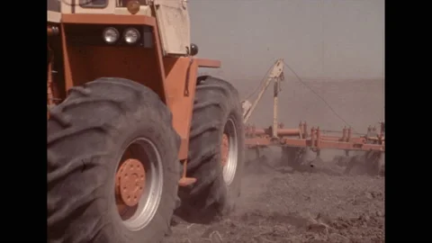 1970s: Man in tractor pulls disc harrow ... | Stock Video | Pond5