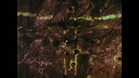 1970s: Marked holes bored into rock wall... | Stock Video | Pond5