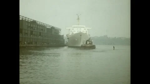 1970s: Ship by dock, tug boat on water. | Stock Video | Pond5