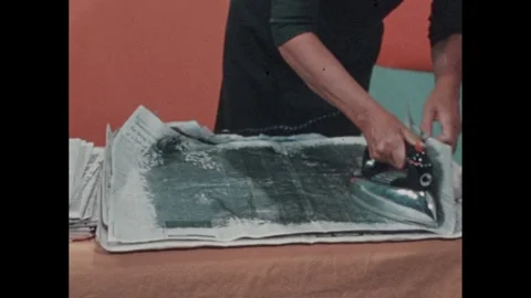 1970s: Woman irons newspaper, then pulls... | Stock Video | Pond5