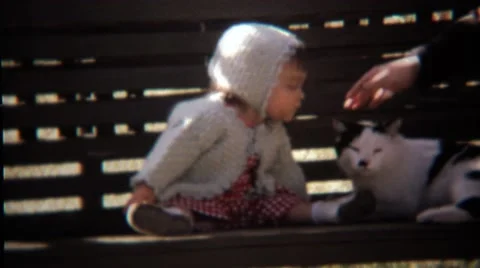 1971: Toddler girl sitting on park bench... | Stock Video | Pond5