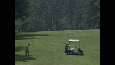 1980s: Golf carts driving along pathway.... | Stock Video | Pond5