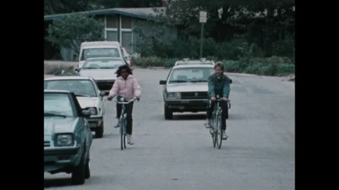 1980s: Two kids ride bikes side by side ... | Stock Video | Pond5