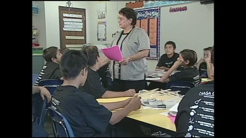 1990s: Teacher stands in classroom talki... | Stock Video | Pond5