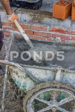 2 wheel concrete cart with concrete and shovel ~ Premium Photo #77087674