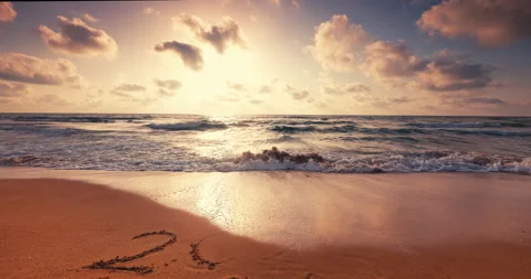 2024 new year text written in sand on a ... | Stock Video | Pond5