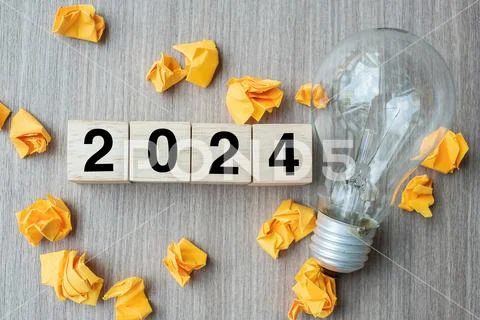 2024 text wood cube blocks and crumbled paper with lightbulb on wooden ...
