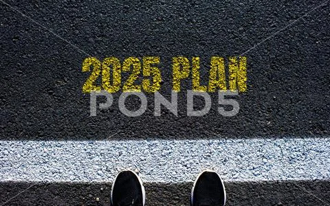 Photograph: 2025 plan message written on asphalt road. Conceptual 2025 ...