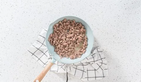Flat lay. Browning ground turkey on a nonstick frying pan to bake ...