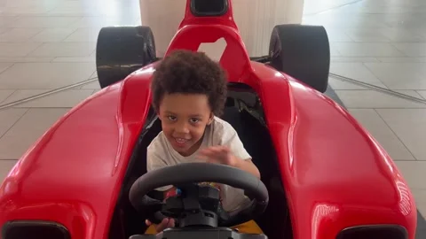 3 year-old black child driving a red F1 ... | Stock Video | Pond5