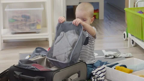 3-year-old child unpacking travel suitca... | Stock Video | Pond5