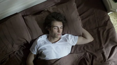 4K Attractive boy sleeping on a bed. Sho... | Stock Video | Pond5