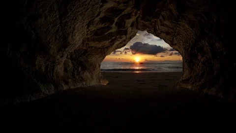 4K - Beach cave with sunrise/sunset over... | Stock Video | Pond5