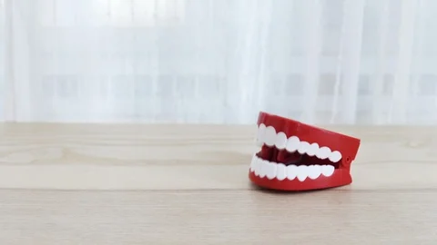 4K Clacking toy teeth on wooden table | Stock Video | Pond5