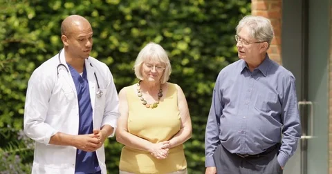 4K Doctor talking to senior couple outsi... | Stock Video | Pond5