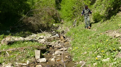 4K .Man tourist go near stream in sunn... | Stock Video | Pond5