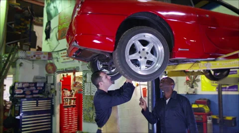 4K Mechanics working underneath a car in... | Stock Video | Pond5
