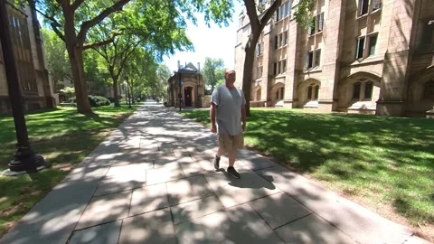 4K Pan following Man walking on Campus | Stock Video | Pond5
