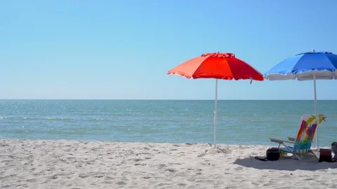 4K Red & Blue beach umbrellas and armcha... | Stock Video | Pond5