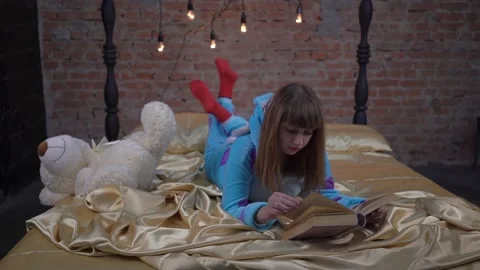 4K Teenage girl reading a book lying on ... | Stock Video | Pond5