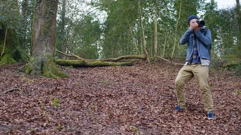 4K Wide shot of photographer in the wood... | Stock Video | Pond5